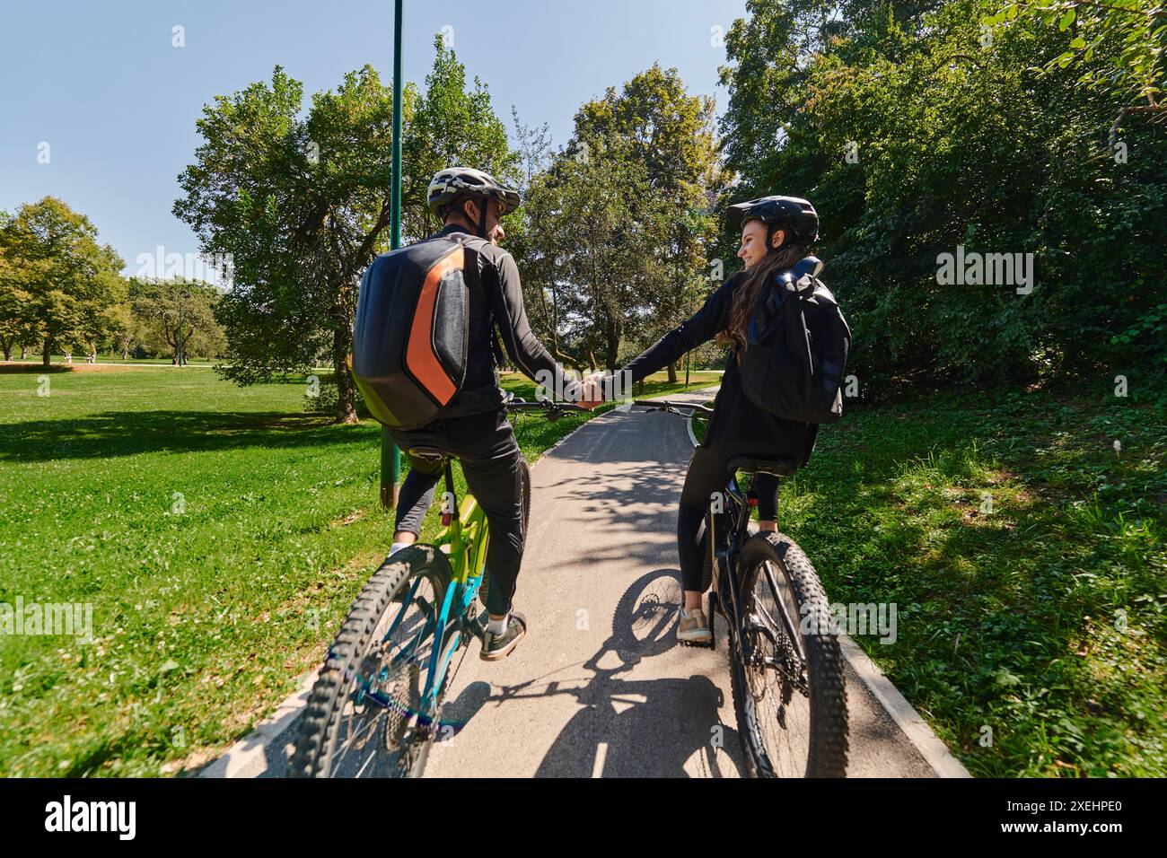 A sweet couple, adorned in cycling gear, rides their bicycles, their ...