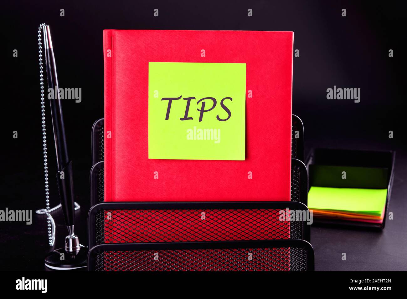 TIPS written on a sticker on a red notebook on a black background Stock ...