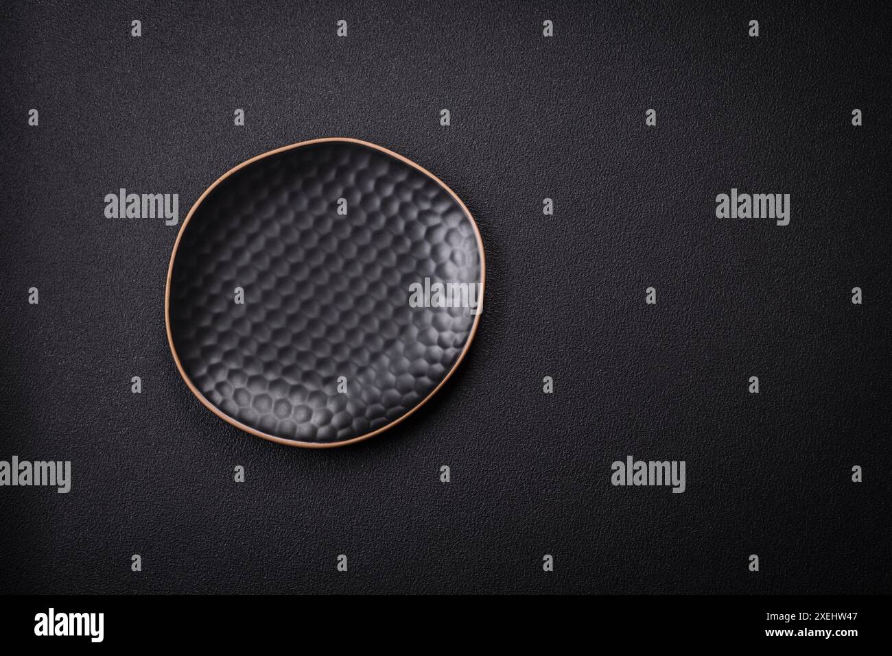 Bumpy empty ceramic plate on a textured concrete background Stock Photo ...