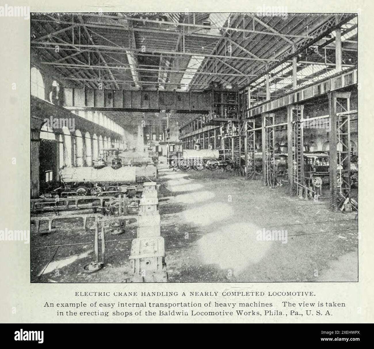 ELECTRIC CRANE HANDLING A NEARLY COMPLETED LOCOMOTIVE. An example of ...