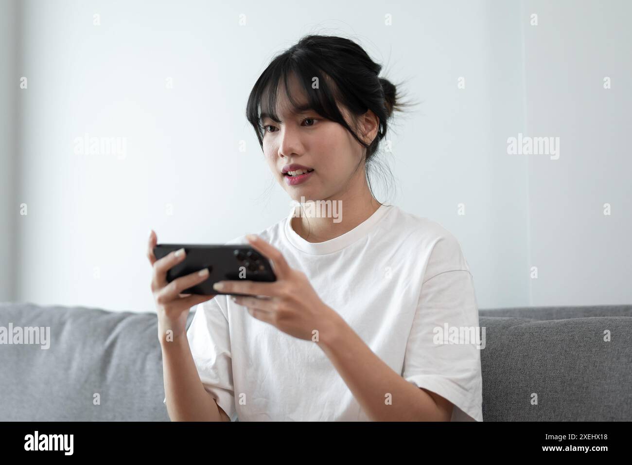 Asian woman playing game on mobile phone. gamer girl playing video ...