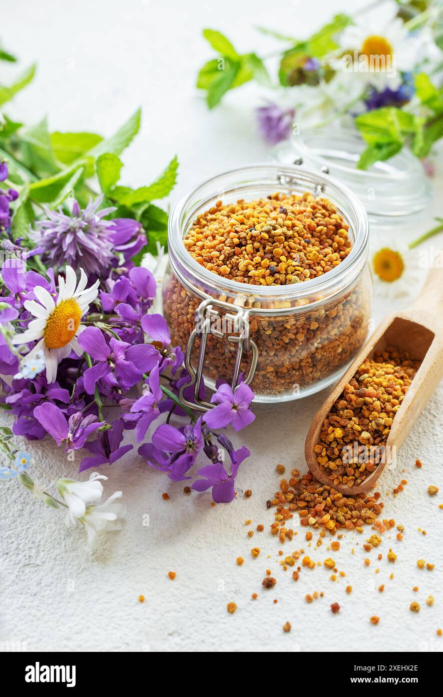 Healthy bee pollen grains. Bee pollen on a glass jar and wild flowers ...