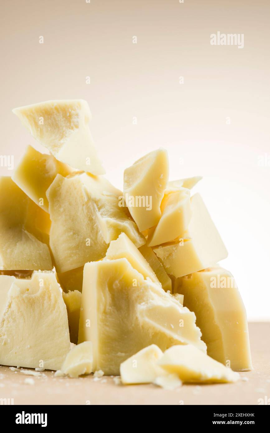 Pile of white chocolate flakes on cream colored background Stock Photo ...