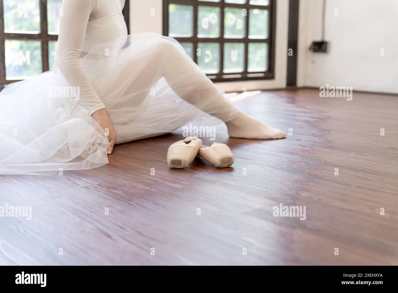 Ballerina in ballet shoes. Asian girlÂ tying ribbons of toe shoes ...