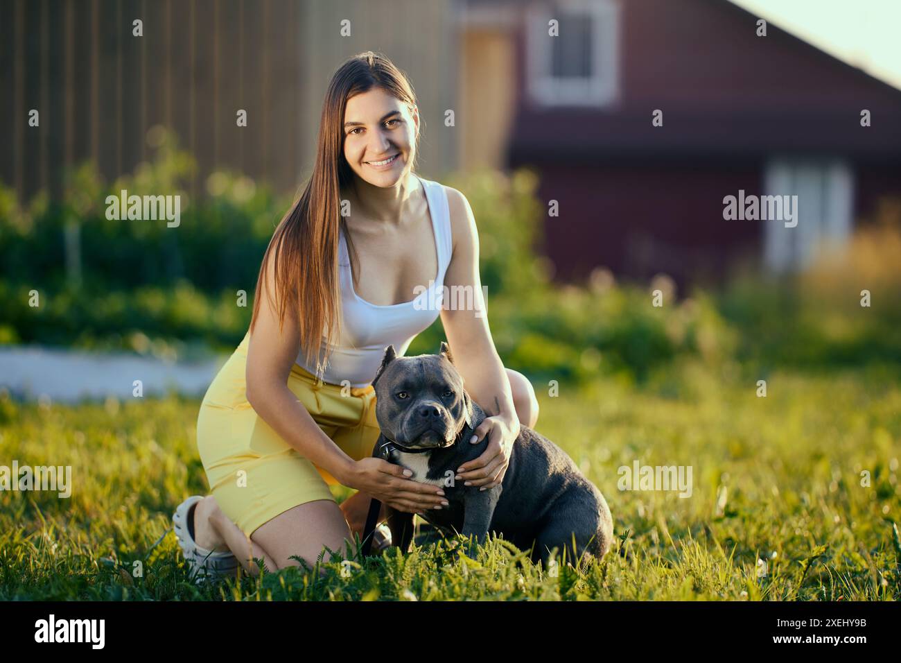 Caucasian woman poses for photo with her American Bully breed dog ...