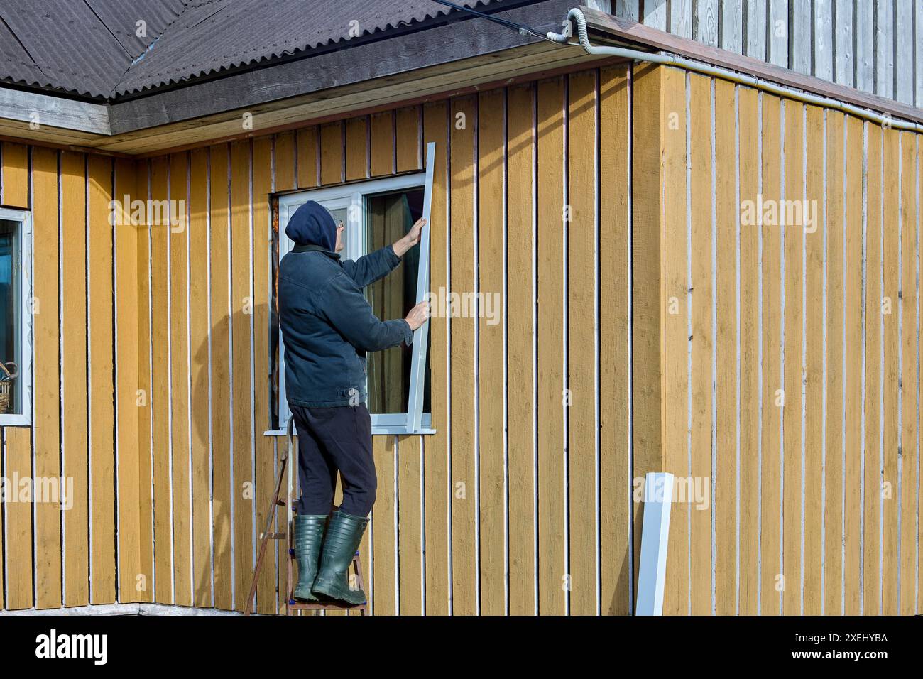 Outdoor work on window openings, roofer installs metal window slopes on ...