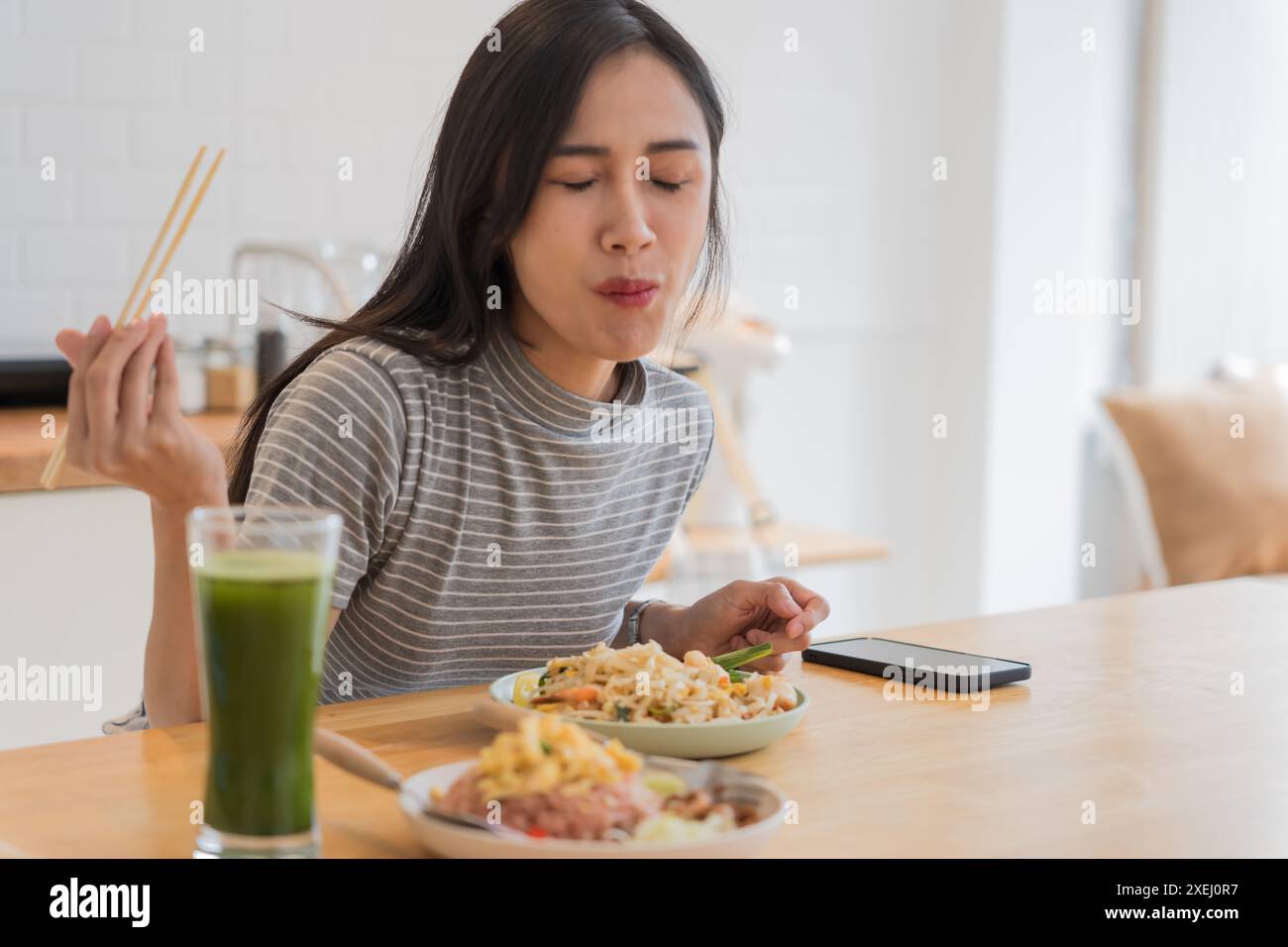 Asian Girl Â eating Thai food in kitchen counter Home delivery food ...