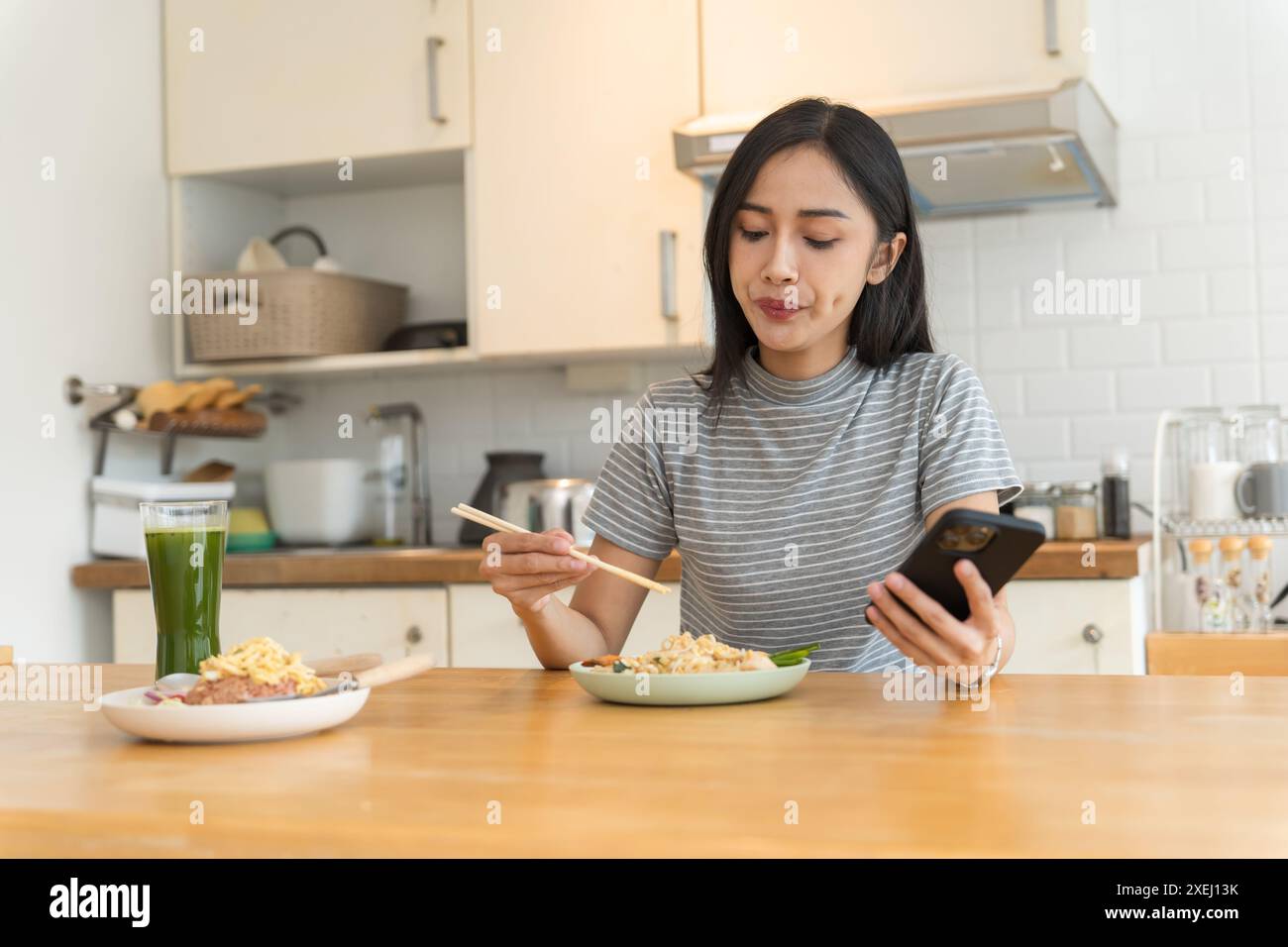Asian Girl Â eating Thai food in kitchen counter Home delivery food ...