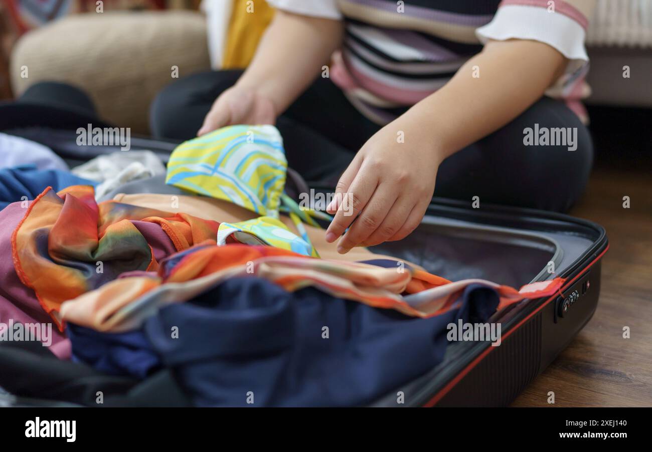 Woman packs baggage in suitcase for new journeyÂ packing a luggage ...