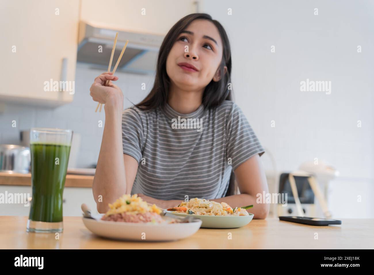 Asian Girl Â eating Thai food in kitchen counter Home delivery food ...
