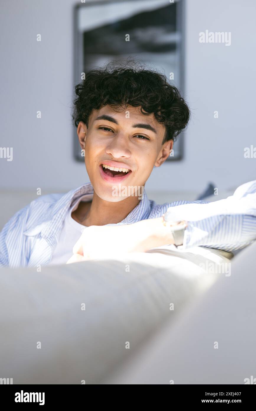 Smiling teenage boy relaxing at home, expressing joy and comfort ...