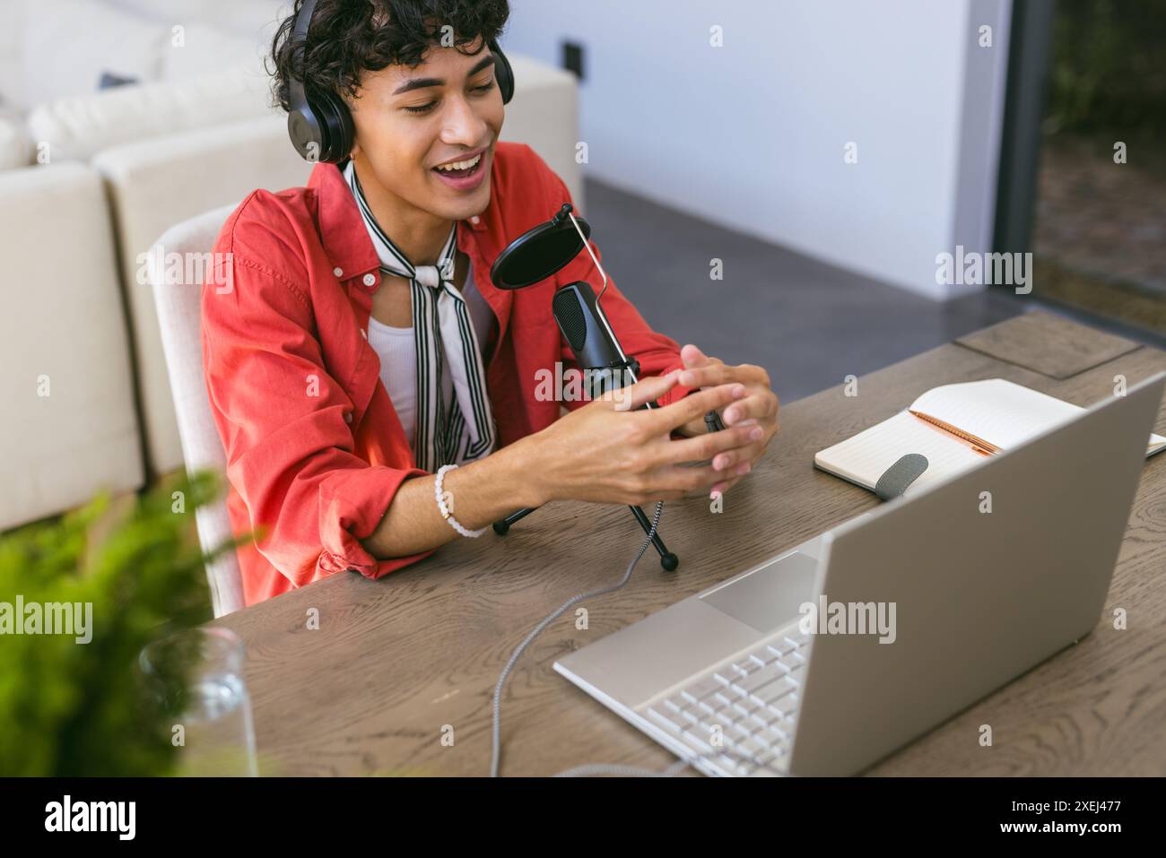 Recording podcast, young man using microphone and laptop at home office ...