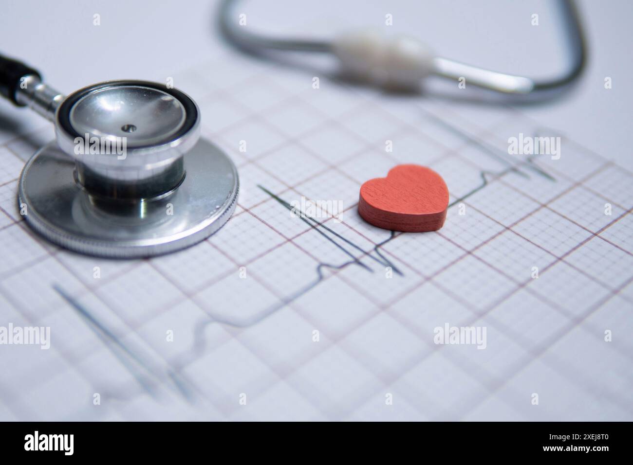 Closeup image of a stethoscope and red heart on a electrocardiogram ...