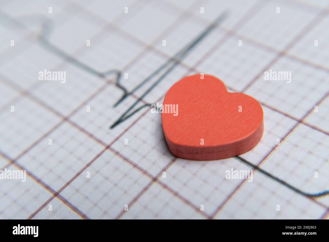 Closeup image of a red heart on a electrocardiogram (ECG) printout. The ...