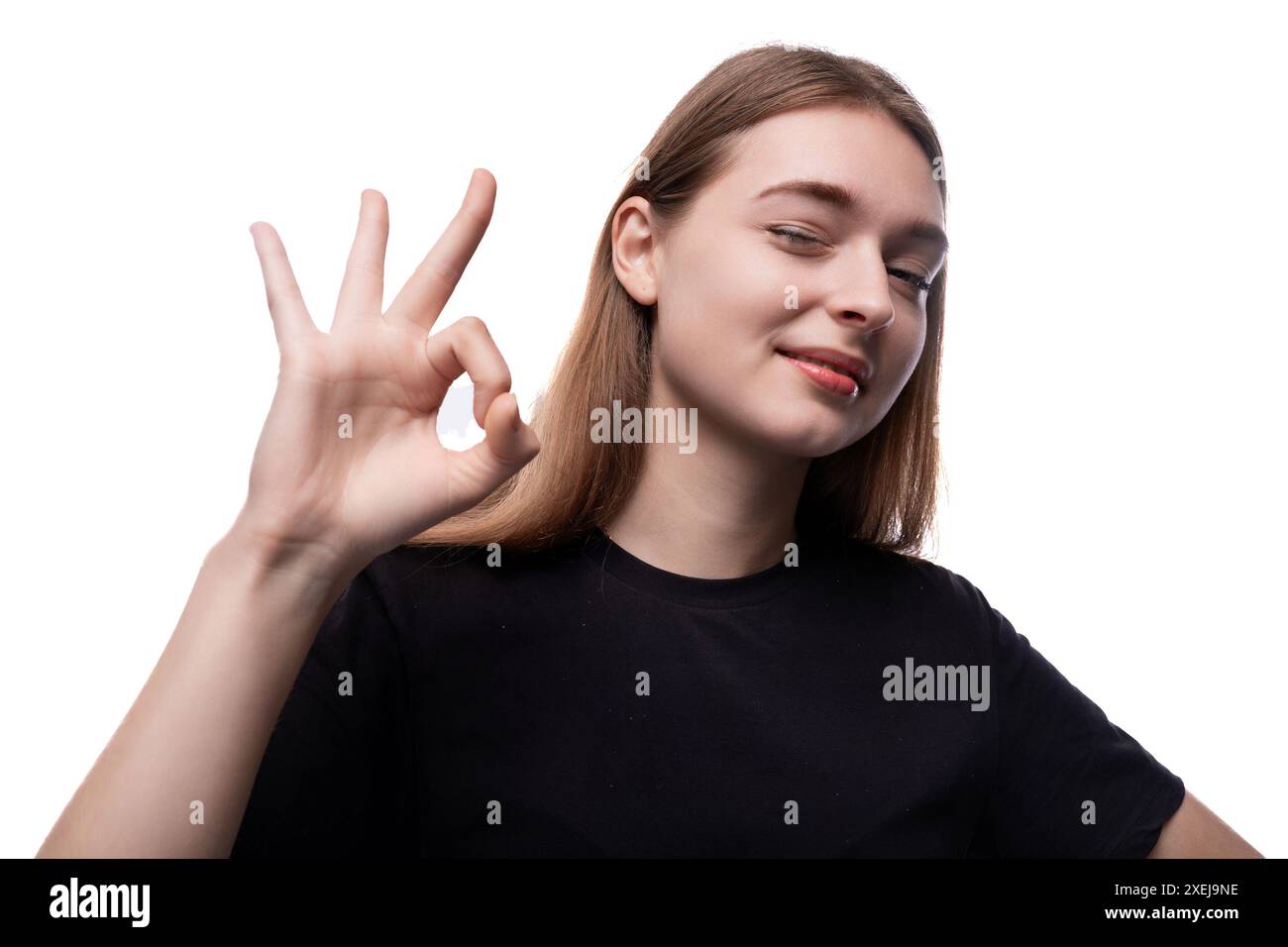 A school-age girl with brown hair in a black T-shirt smiles and looks ...
