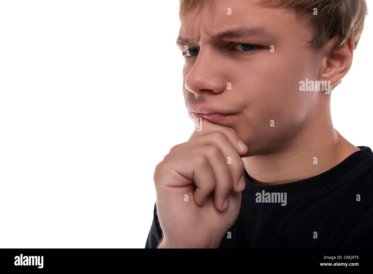 Puzzled teenager guy with blond hair furrowed his eyebrows Stock Photo ...