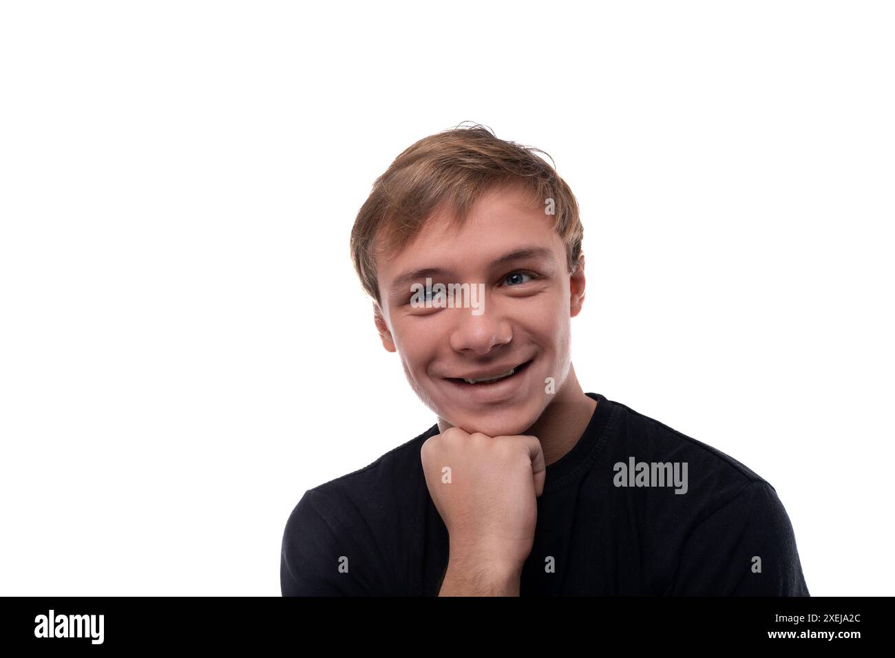 Positive Caucasian fair-haired teenager guy smiling at the camera on a ...