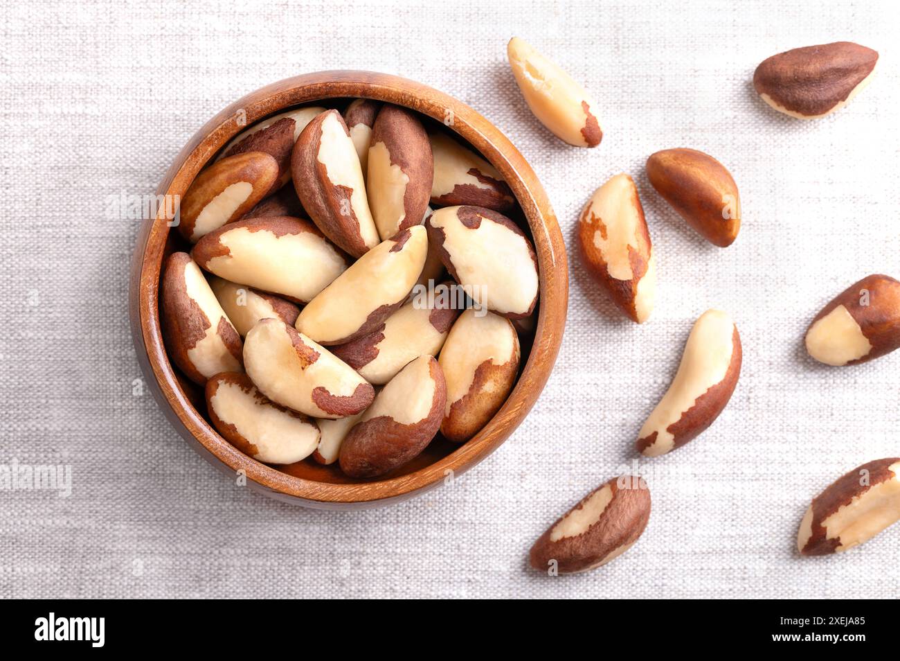 Brazil nuts in a wooden bowl on linen fabric. Dried seeds of ...