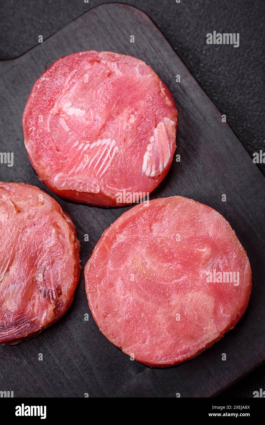 Round shape steaks of raw juicy tuna with salt and spices Stock Photo ...