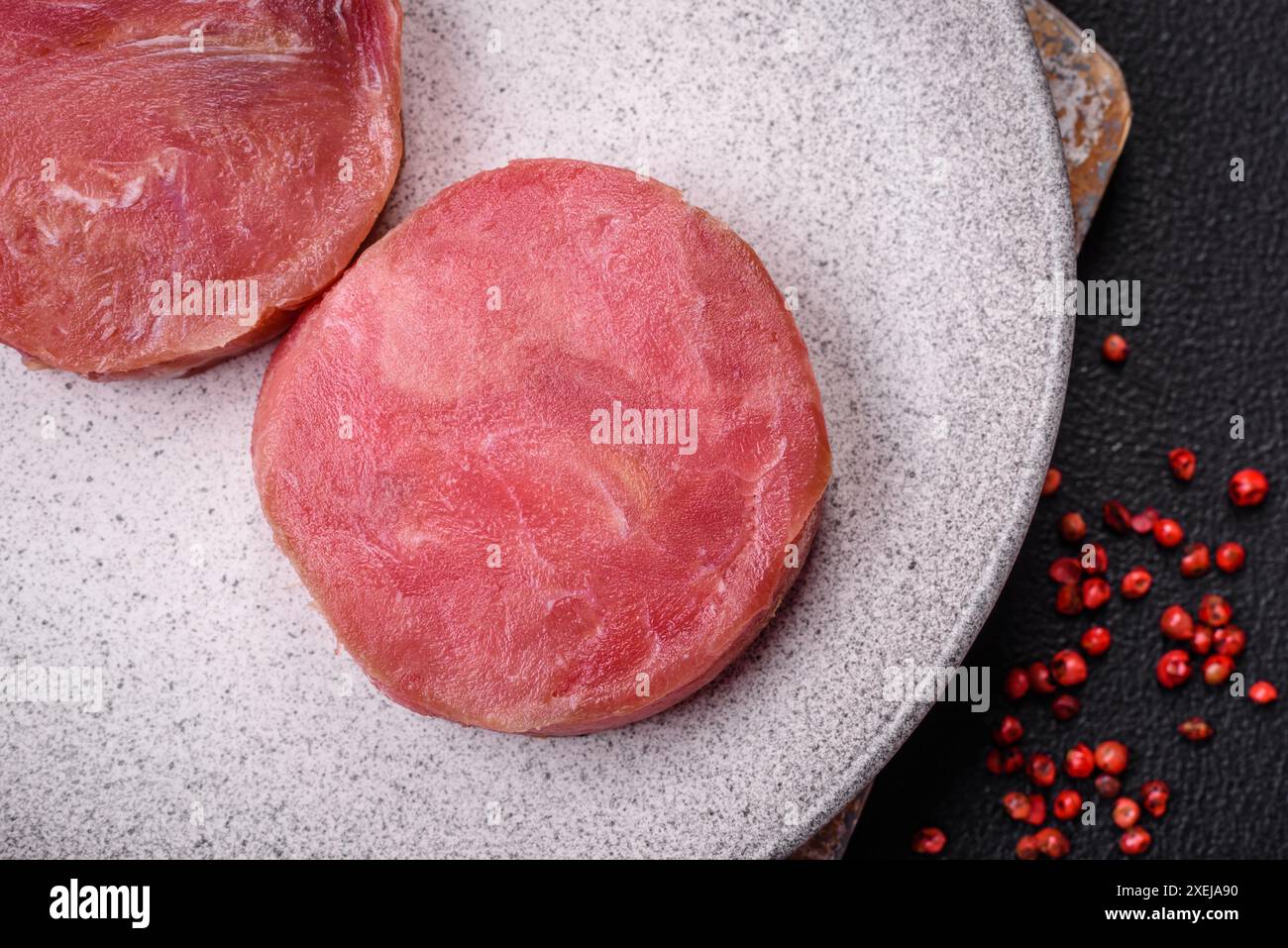 Round shape steaks of raw juicy tuna with salt and spices Stock Photo ...