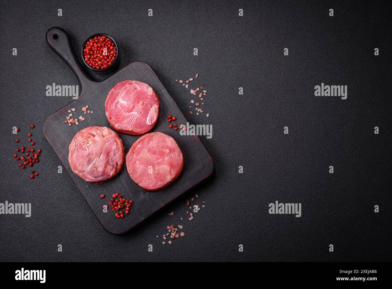 Round shape steaks of raw juicy tuna with salt and spices Stock Photo ...