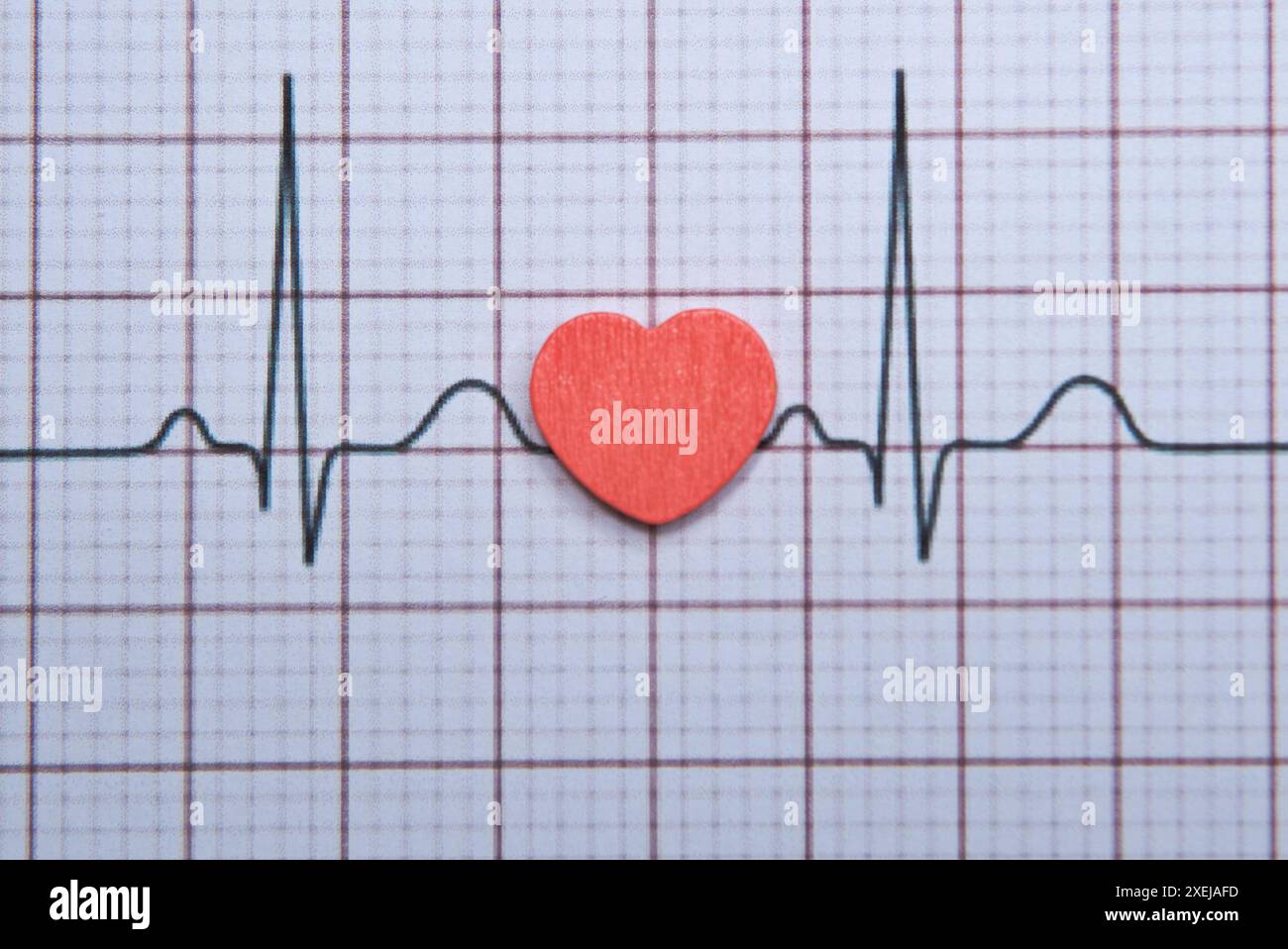 Closeup image of a red heart on a electrocardiogram (ECG) printout. The ...