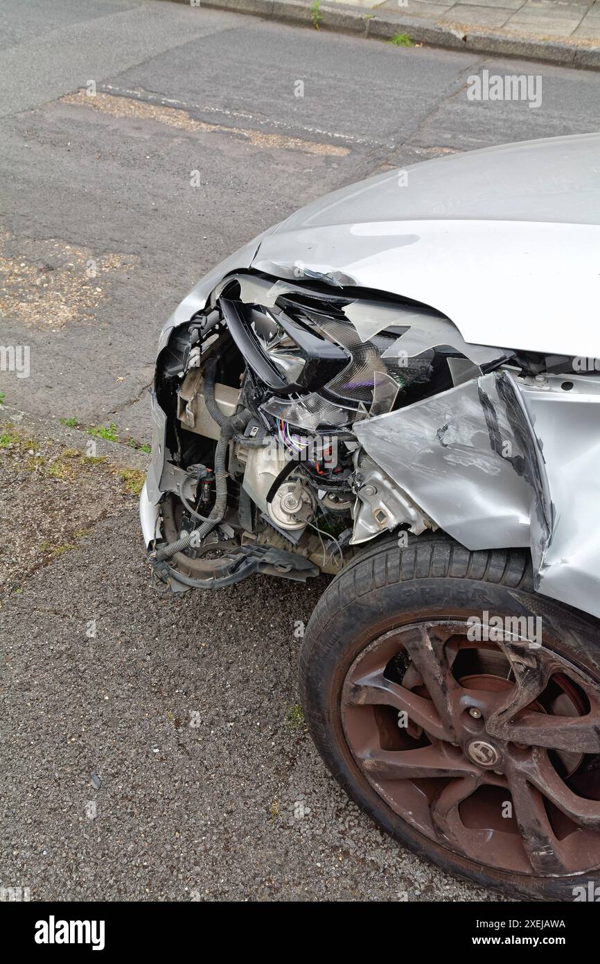 A badly damaged nearside front wing of a small salon car exposing the ...