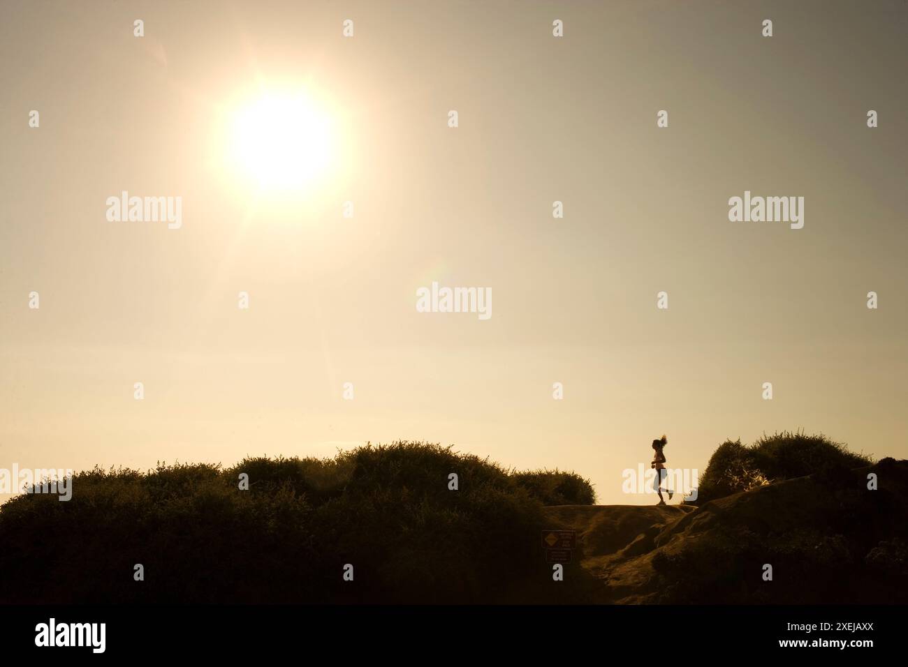 Female runner runs along cliff Stock Photo - Alamy
