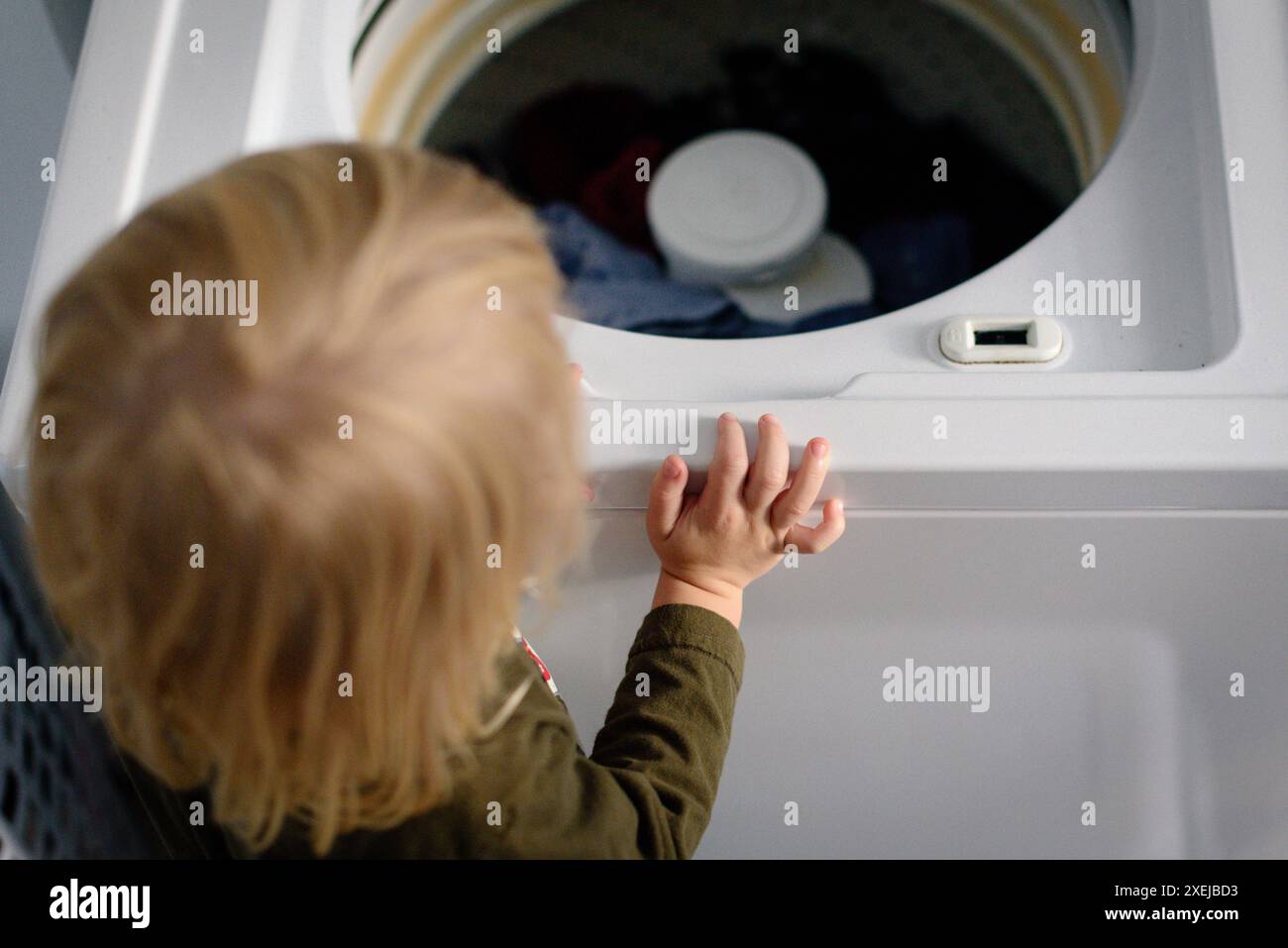 Child looking into a top-loading washing machine Stock Photo - Alamy