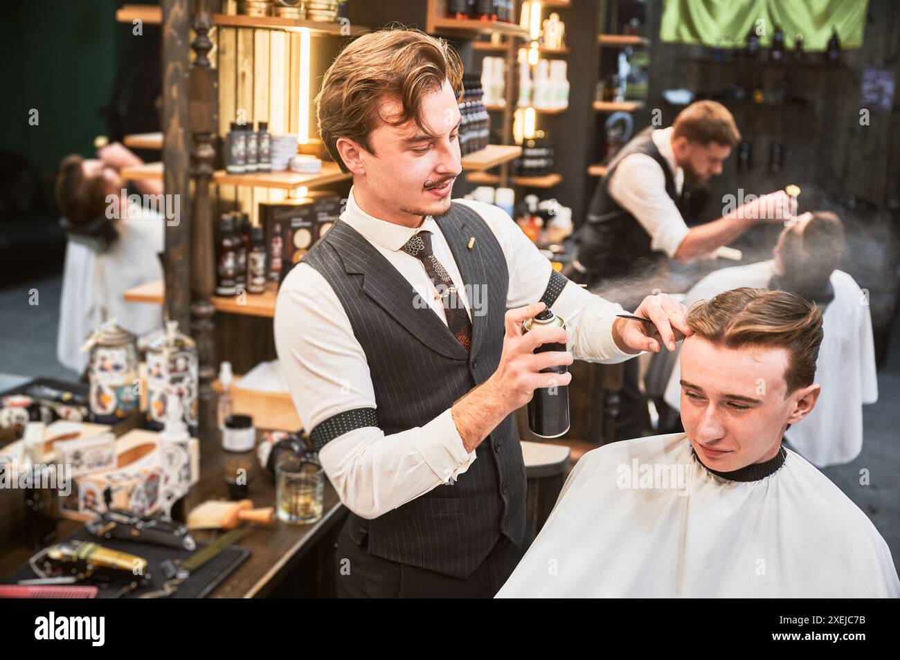 Professional barber using hairspray styling hi-res stock photography ...