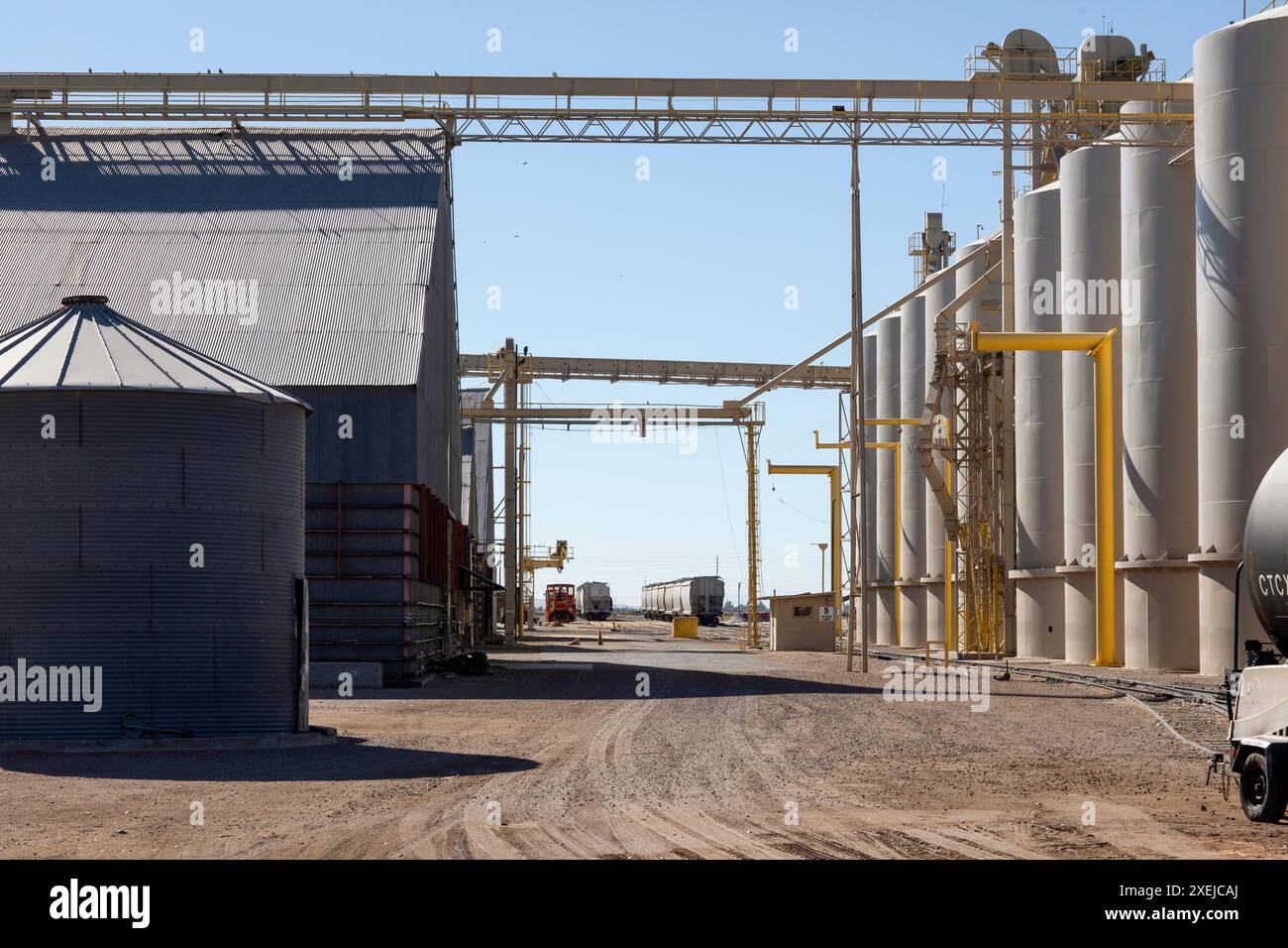 A grain processing facility with train tracks and freight cars Stock ...