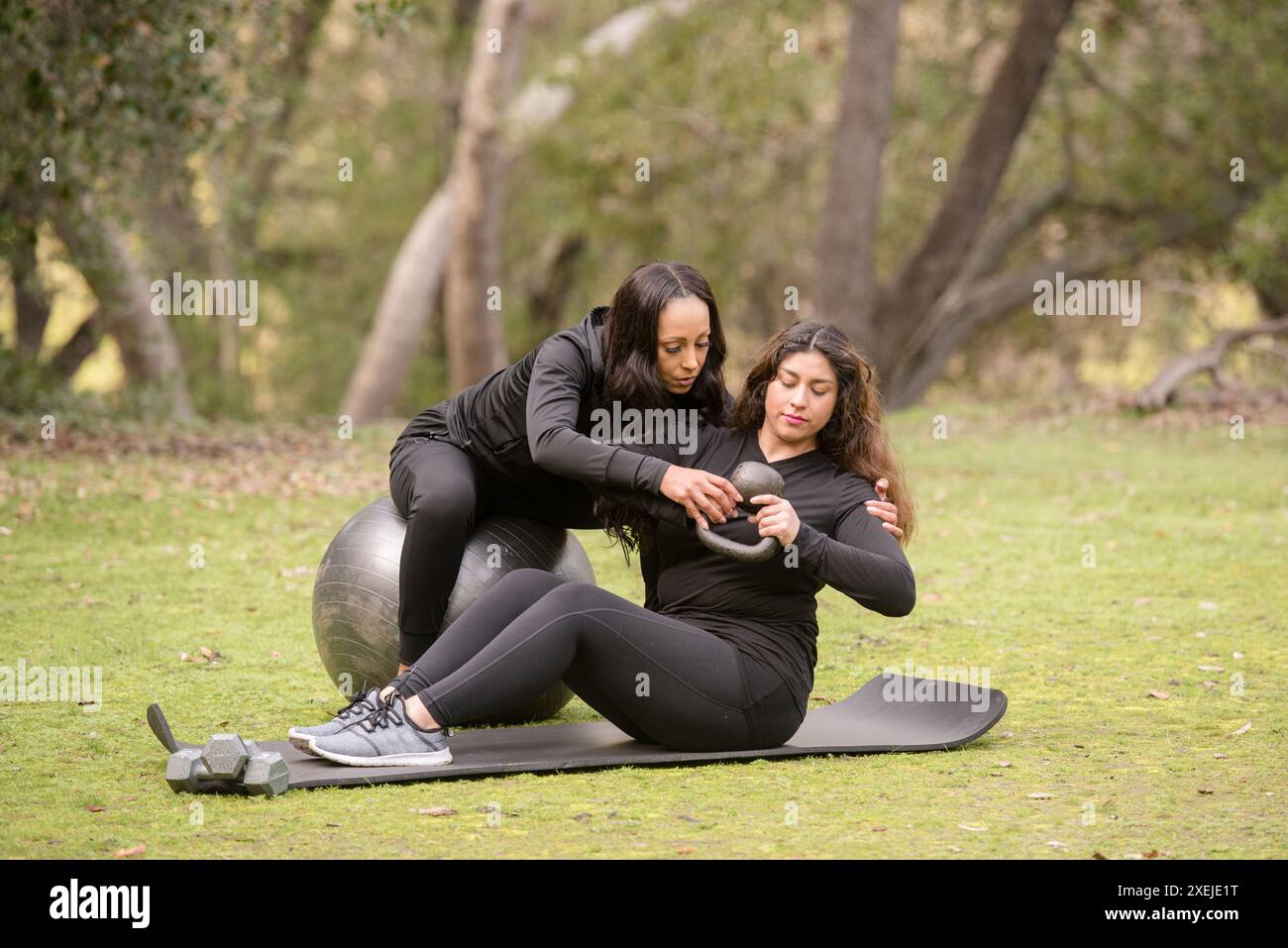 Women trainer showing lady on yoga mat how to workout with dumbb Stock ...