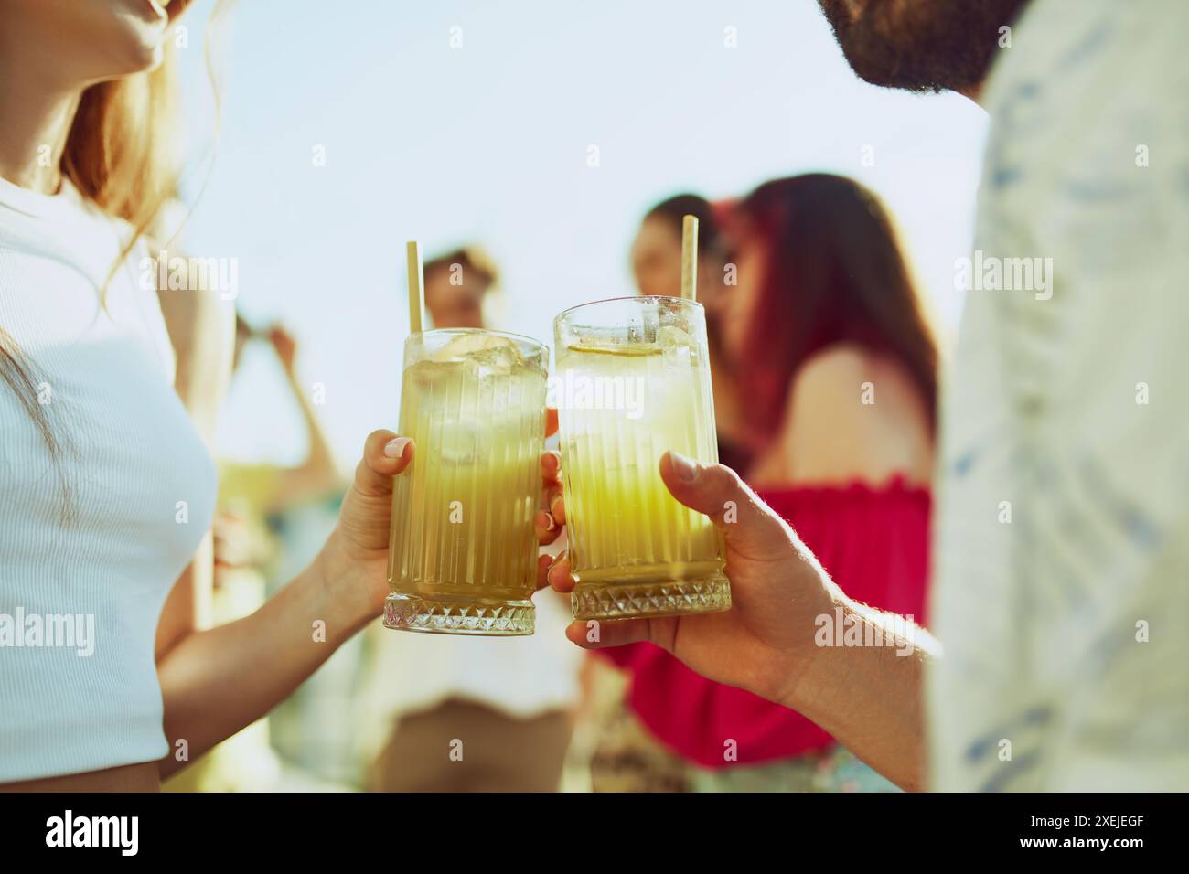 Cool summer vibe. Close-up of two friends toasting with various ...