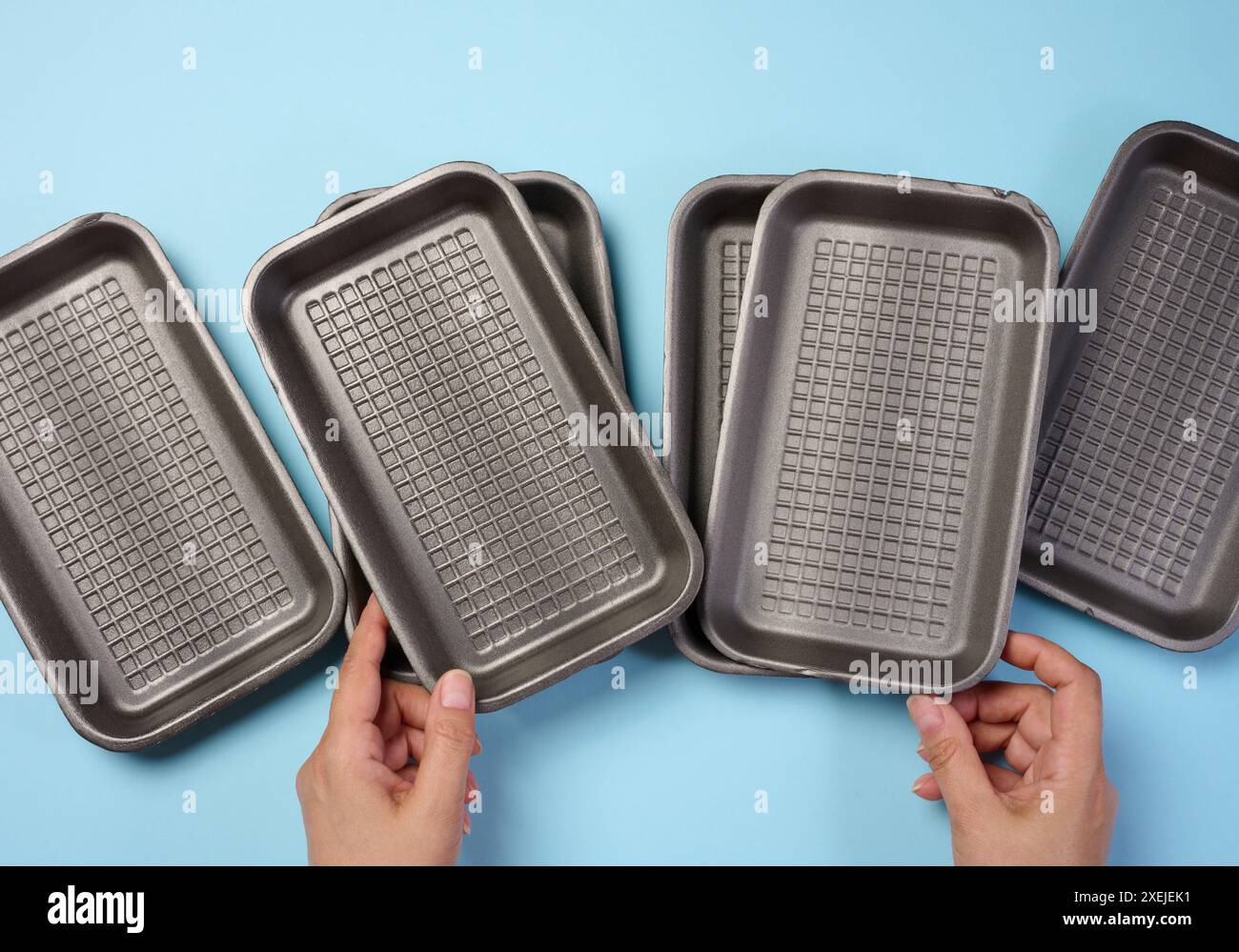 Hand holds black disposable polystyrene foam rectangular plate for ...