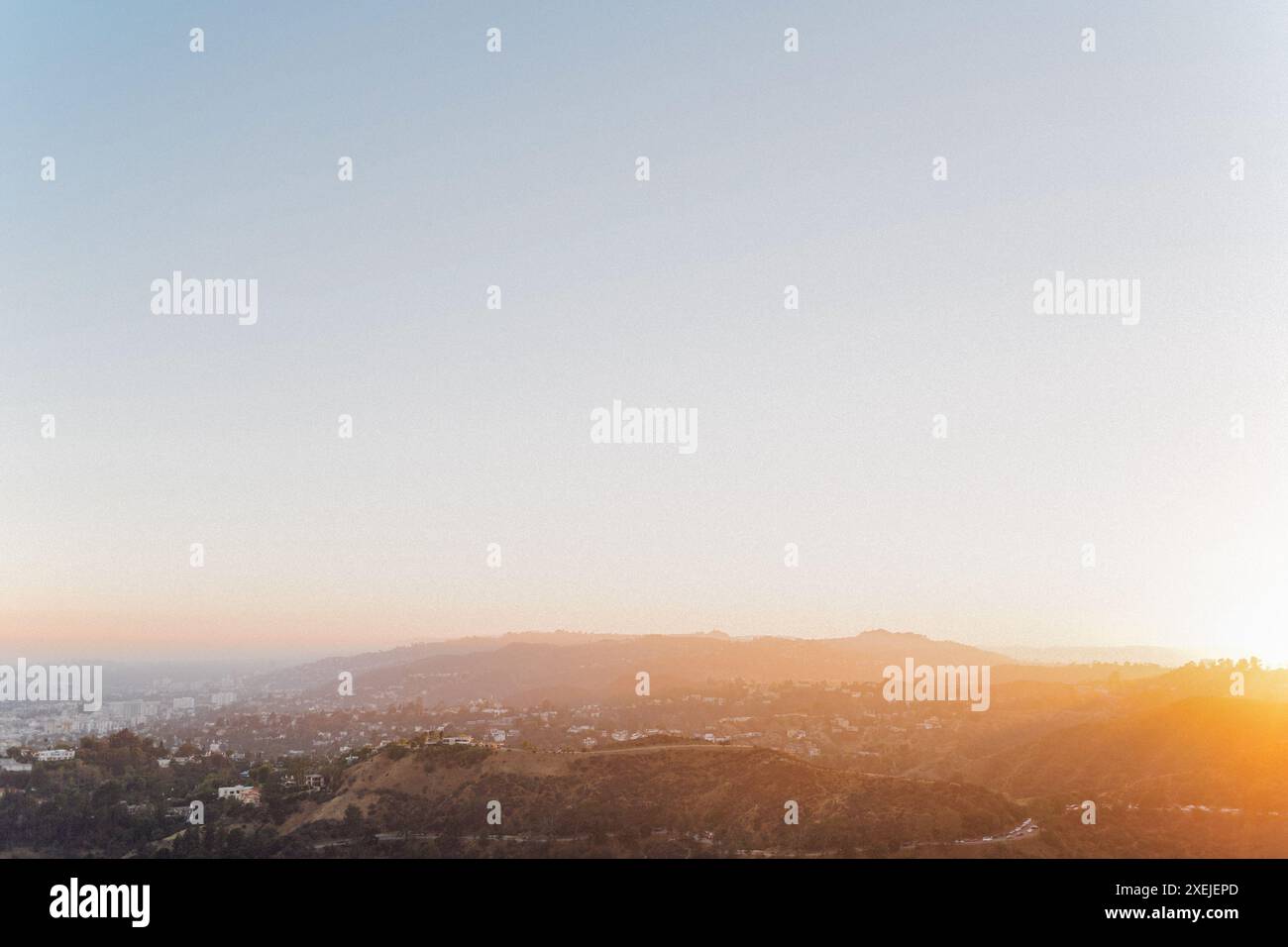 Horizontal image of the sun setting over Los Angeles California hills ...