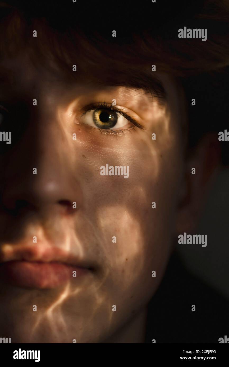 creative close up on teen boy's face with sun flare and shadows Stock ...