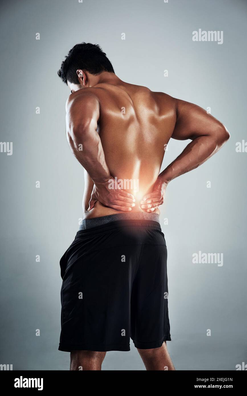 Studio, fitness and man with back pain in gym, glow and cramp at ...