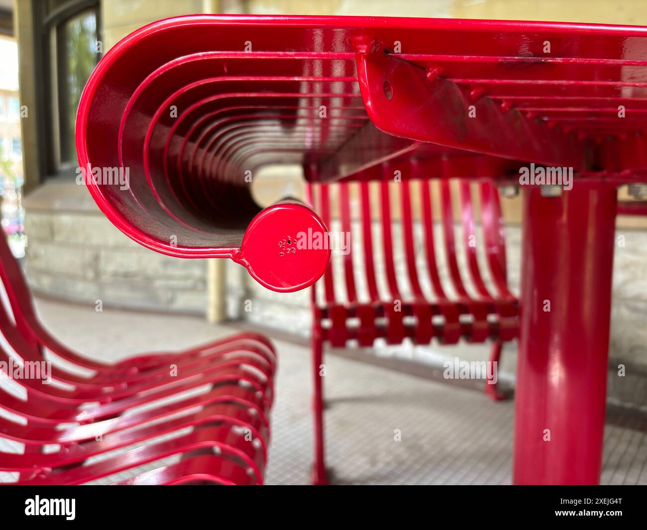 Red lacquer table and chairs on white tile on public library porch ...