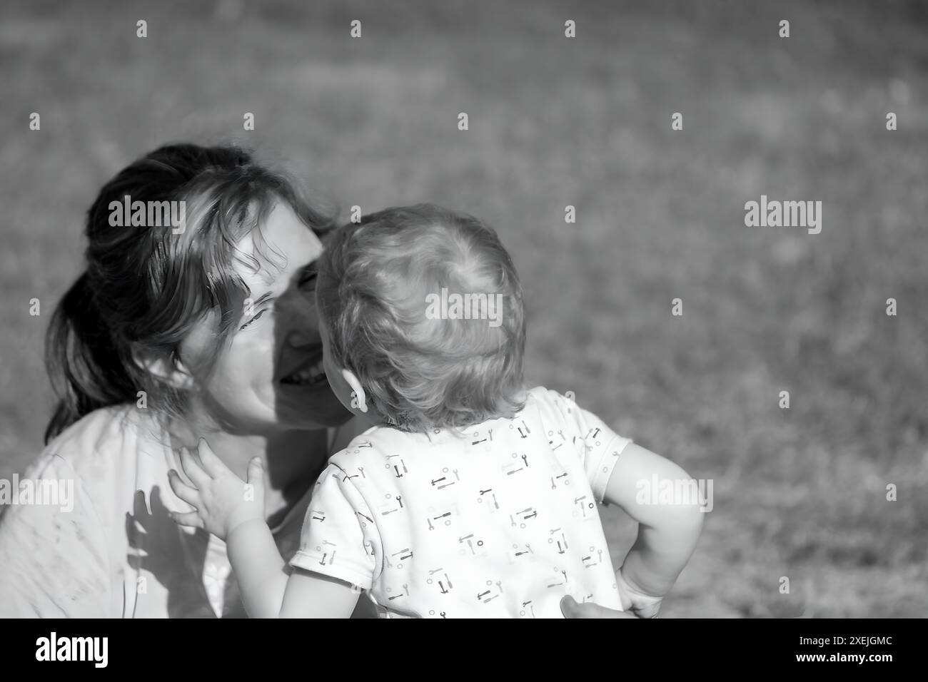 Mother and baby sharing a close moment outdoors, black and white Stock ...