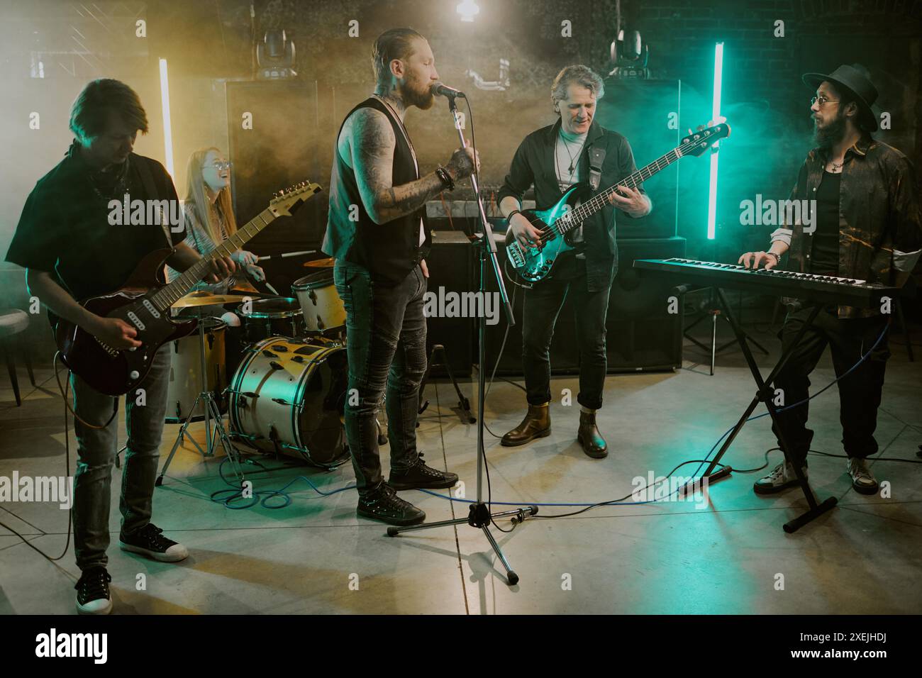 Long shot of modern gen X male and female rock musicians playing song ...