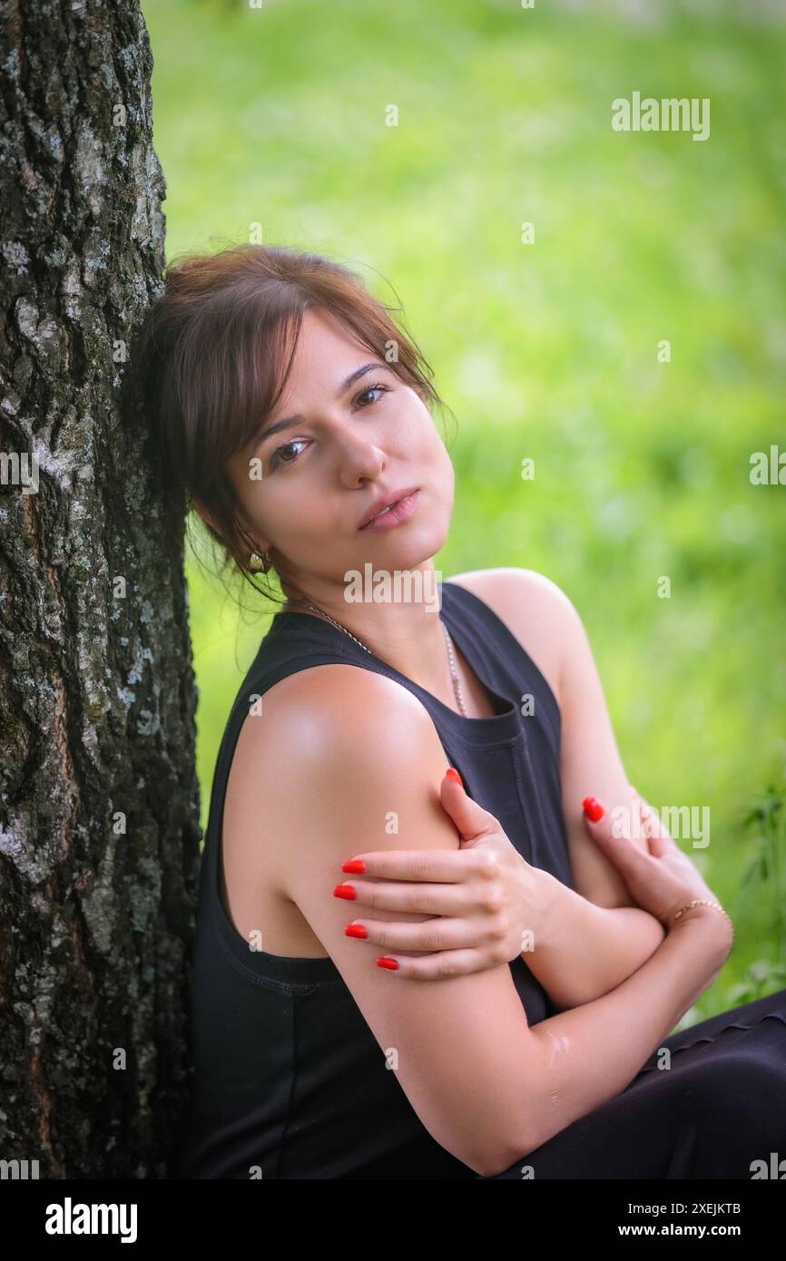 The woman's gaze is full of emotions among the birch grove, creating a ...