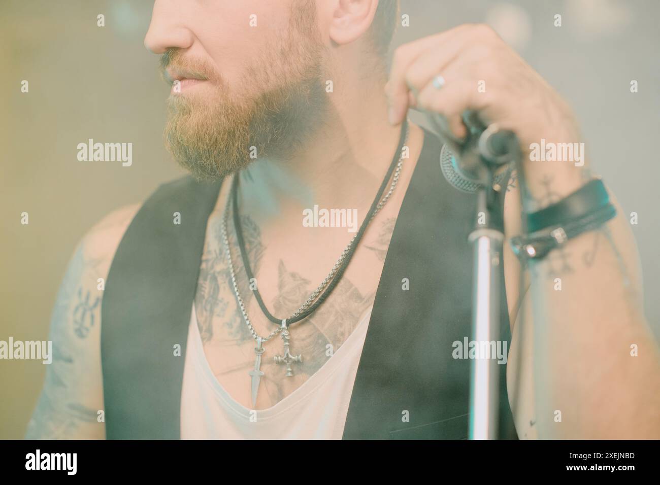 Medium closeup crop shot of bearded frontman of rock band posing on ...
