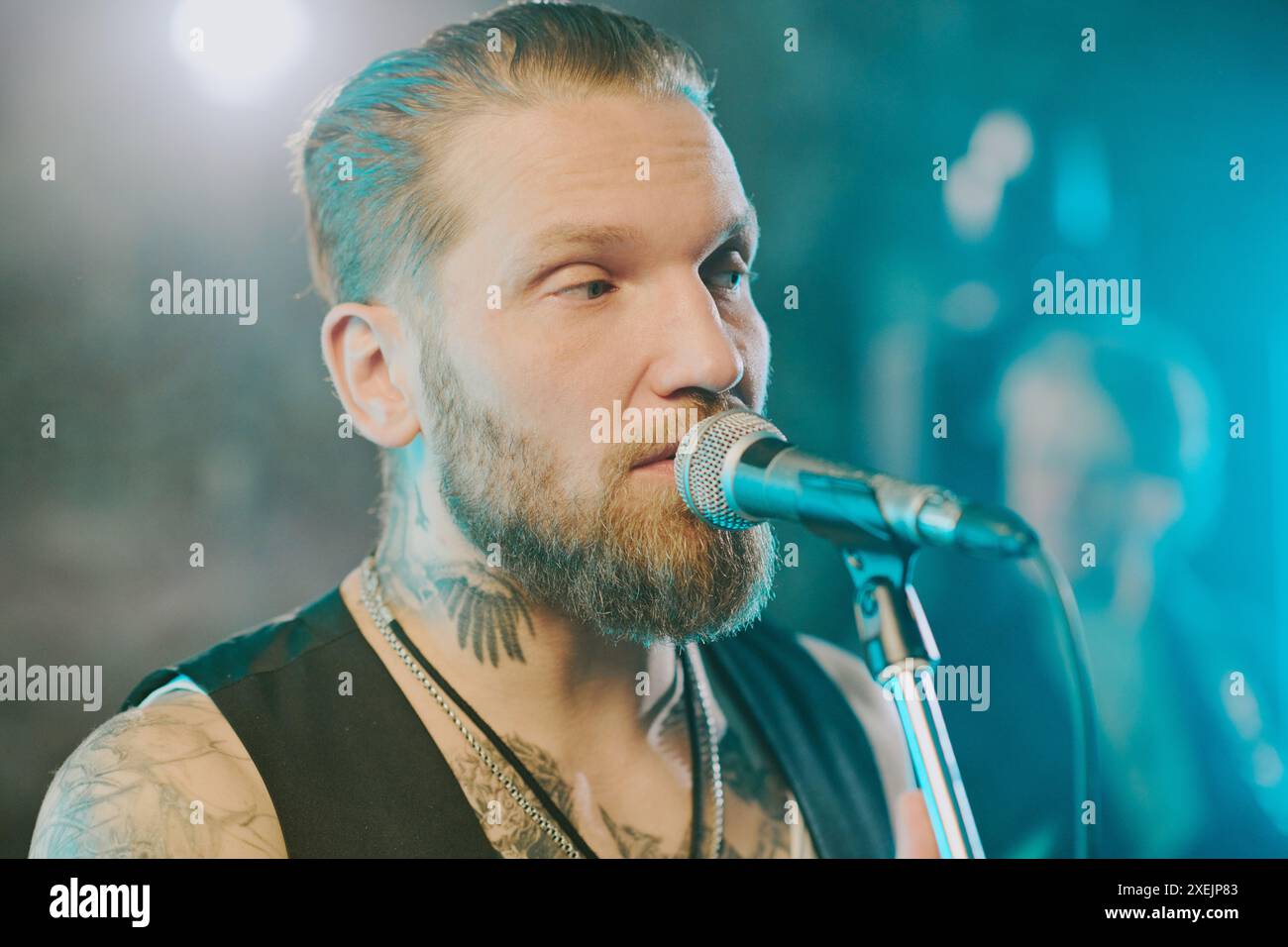 Closeup portrait of bearded Caucasian male vocalist singing rock song ...