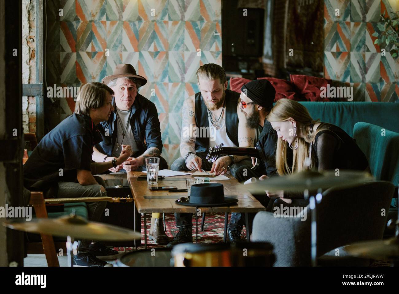 Modern gen X grunge music band sitting in living room in abandoned ...