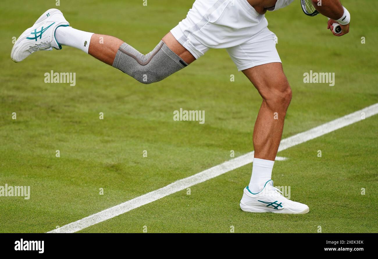 Strapping on the knee of Novak Djokovic on the practice court at the ...