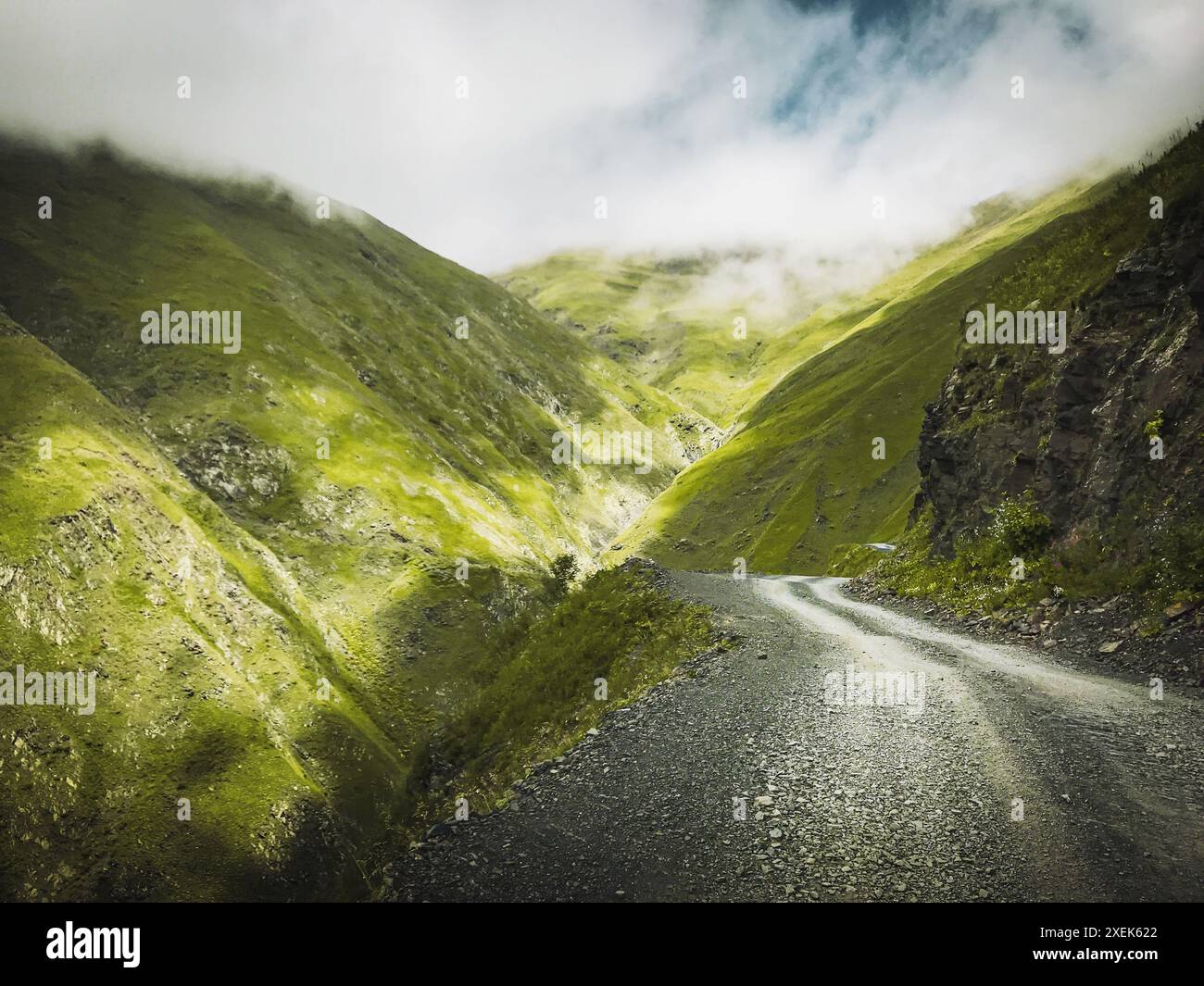 Scenic mountain gravel road in Tusheti region surrounded by foggy ...