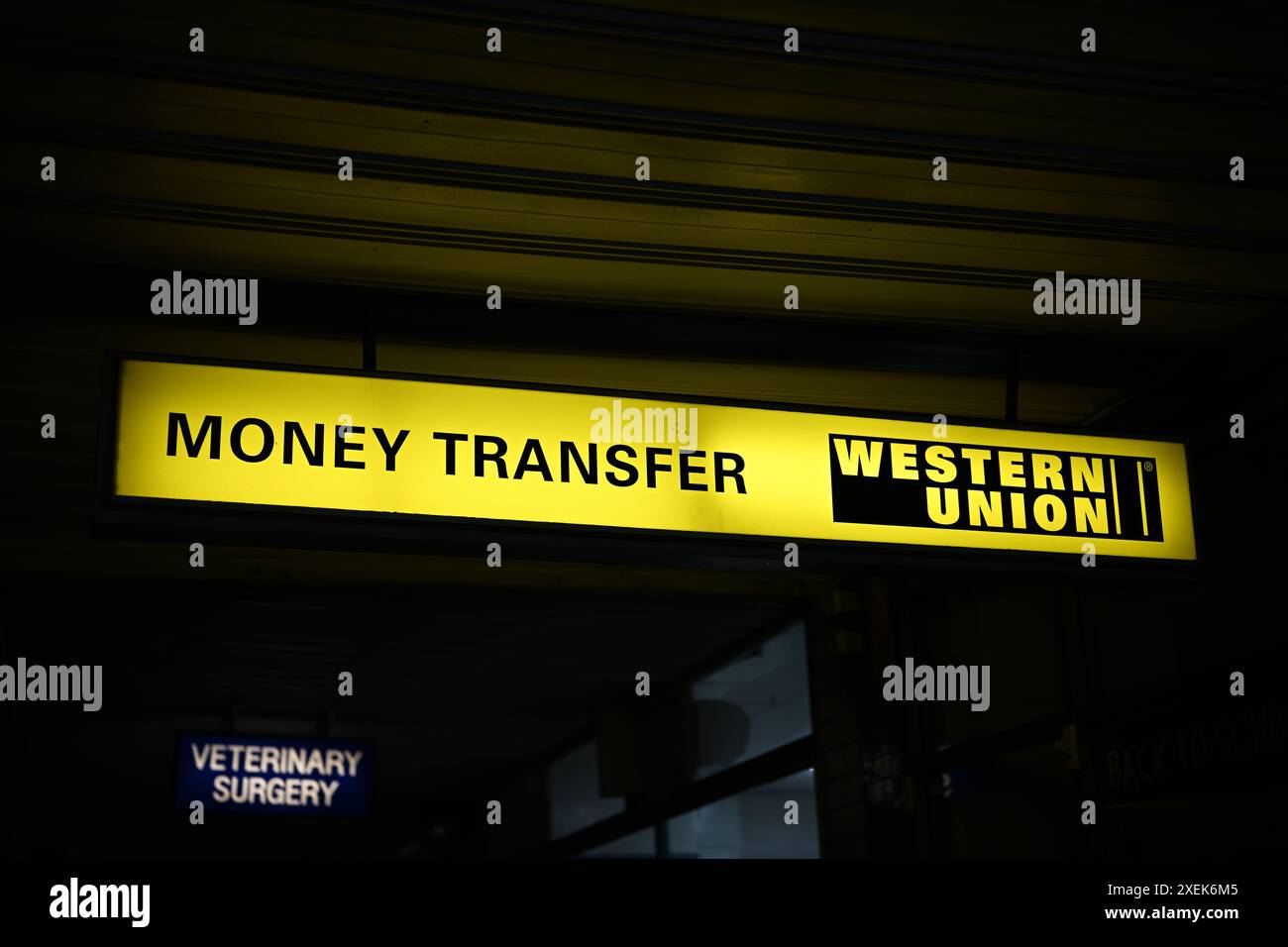 Illuminated yellow and black Western Union money transfer sign hanging ...