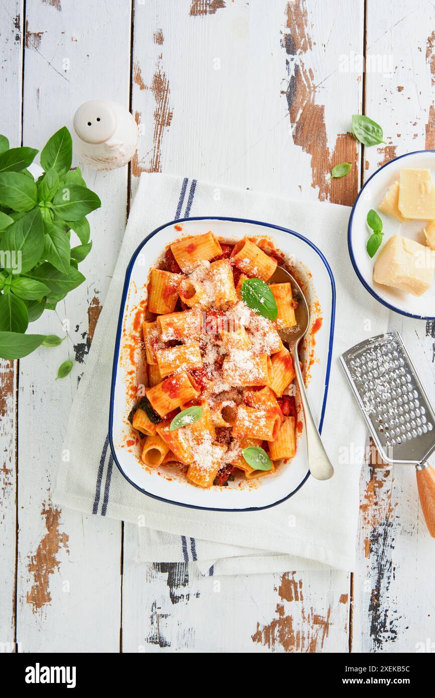 Pasta Rigatoni with parmesan cheese, tomato passata sauce and basil in ...
