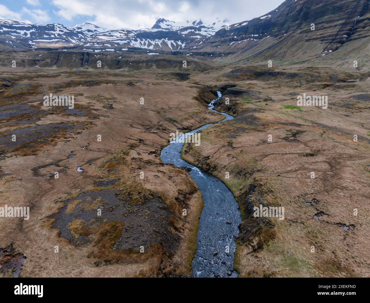 Aerial View of a Serpentine River Through a Snow-Capped Valley in ...