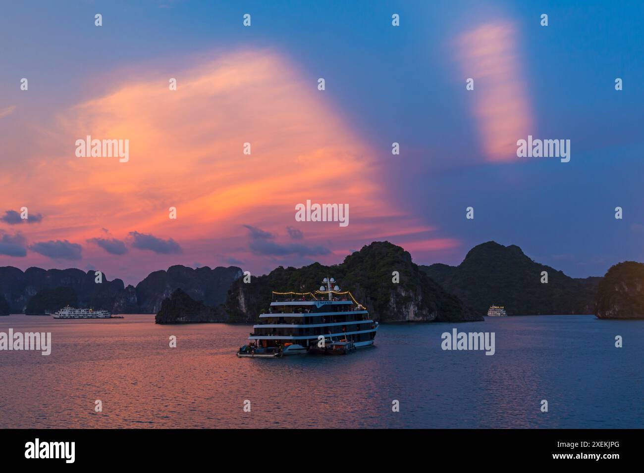 Stunning sunset at Halong Bay Ha long Bay with cruise boats in the bay ...